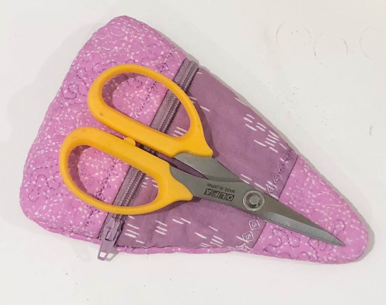 Small yellow-handled scissors on a purple pouch. - Sulky