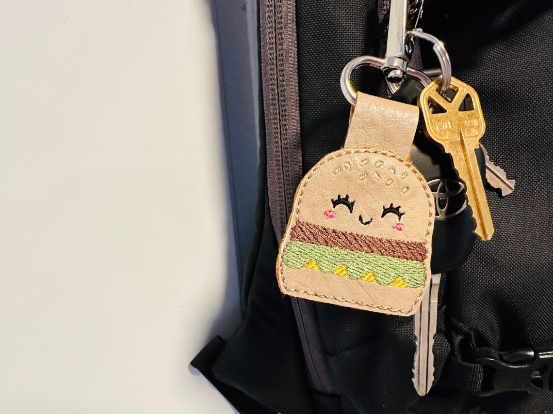 Cute burger keychain attached to a backpack zipper. - Sulky