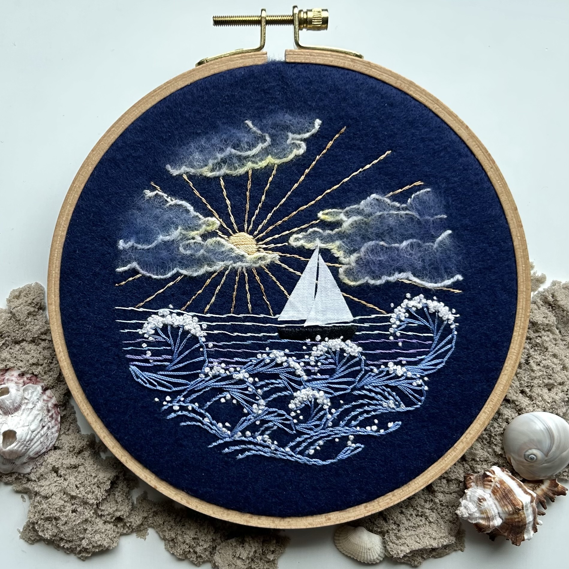 Embroidery of a sailboat on the ocean under a cloudy sky. - Sulky