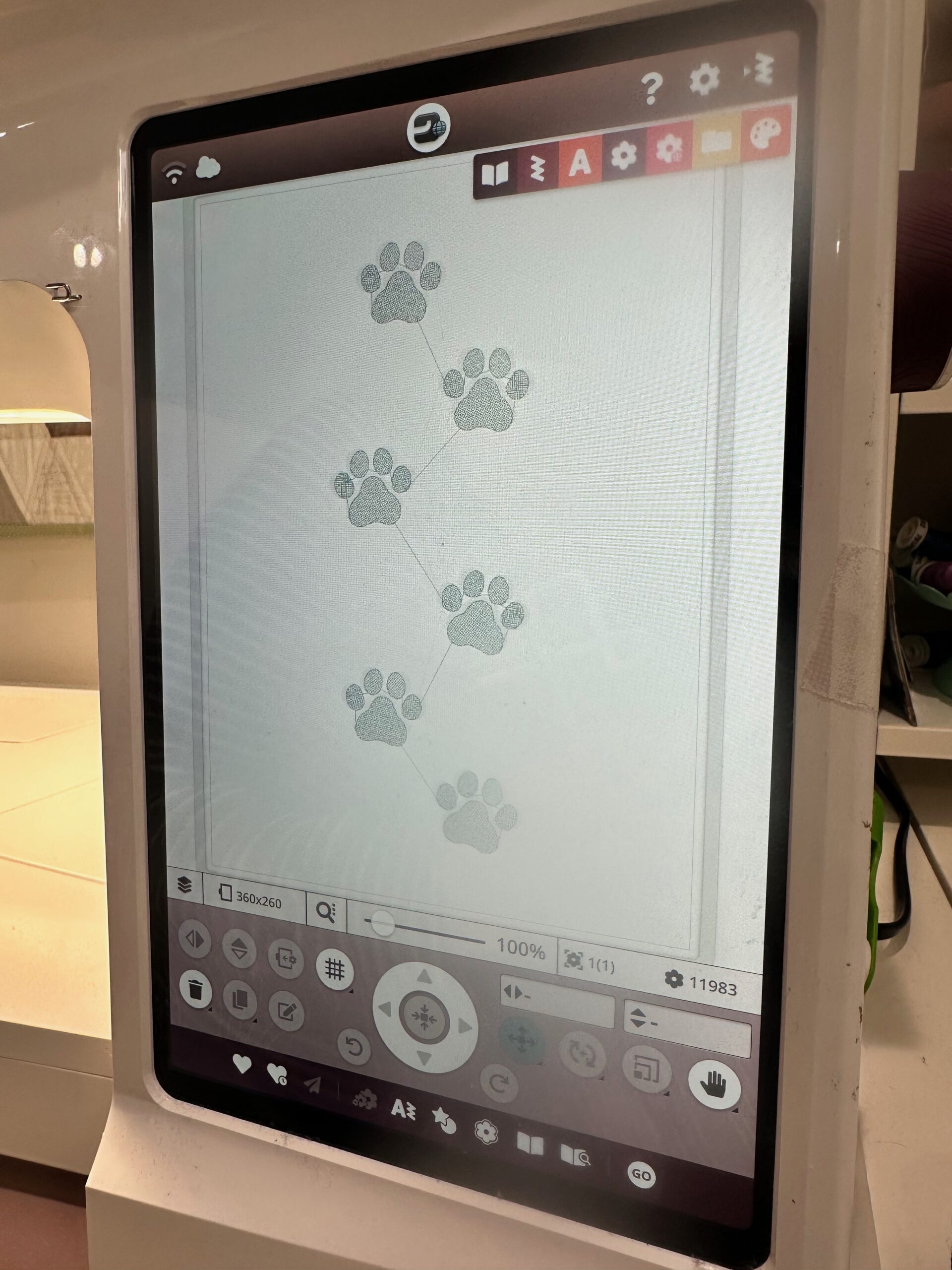 A tablet displaying a drawing app with paw prints and a stylus pen. - Sulky